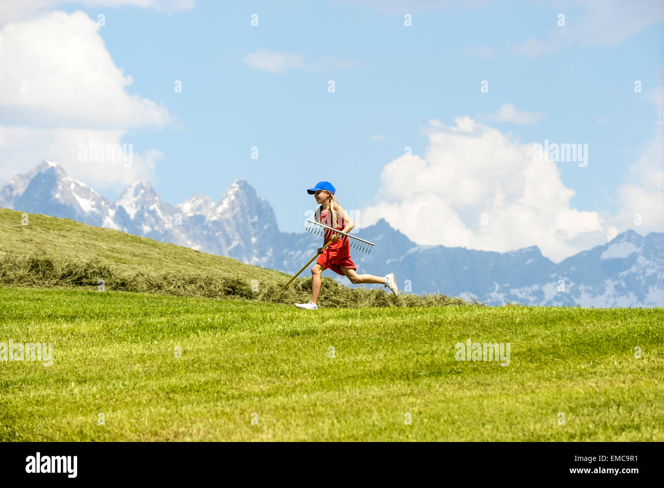 Austria, Flachau, girl running with rake on a harvested meadow Stock ...