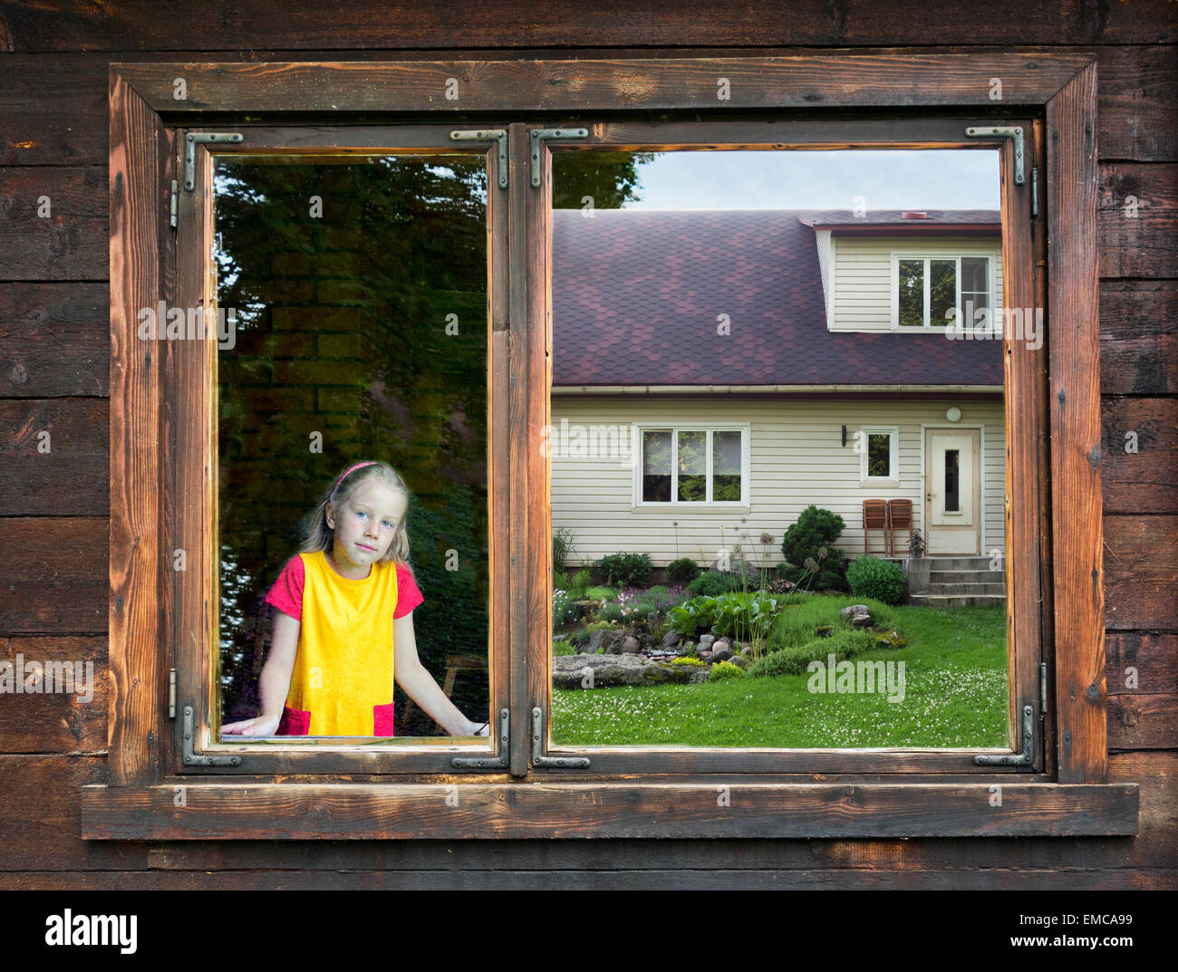 Estonia, girl looking through window of a log cabin Stock Photo - Alamy
