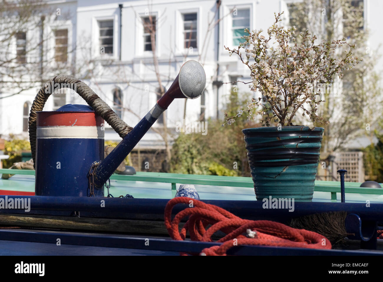 watering can and a pot plant on the top of a Narrow boat moored in ...