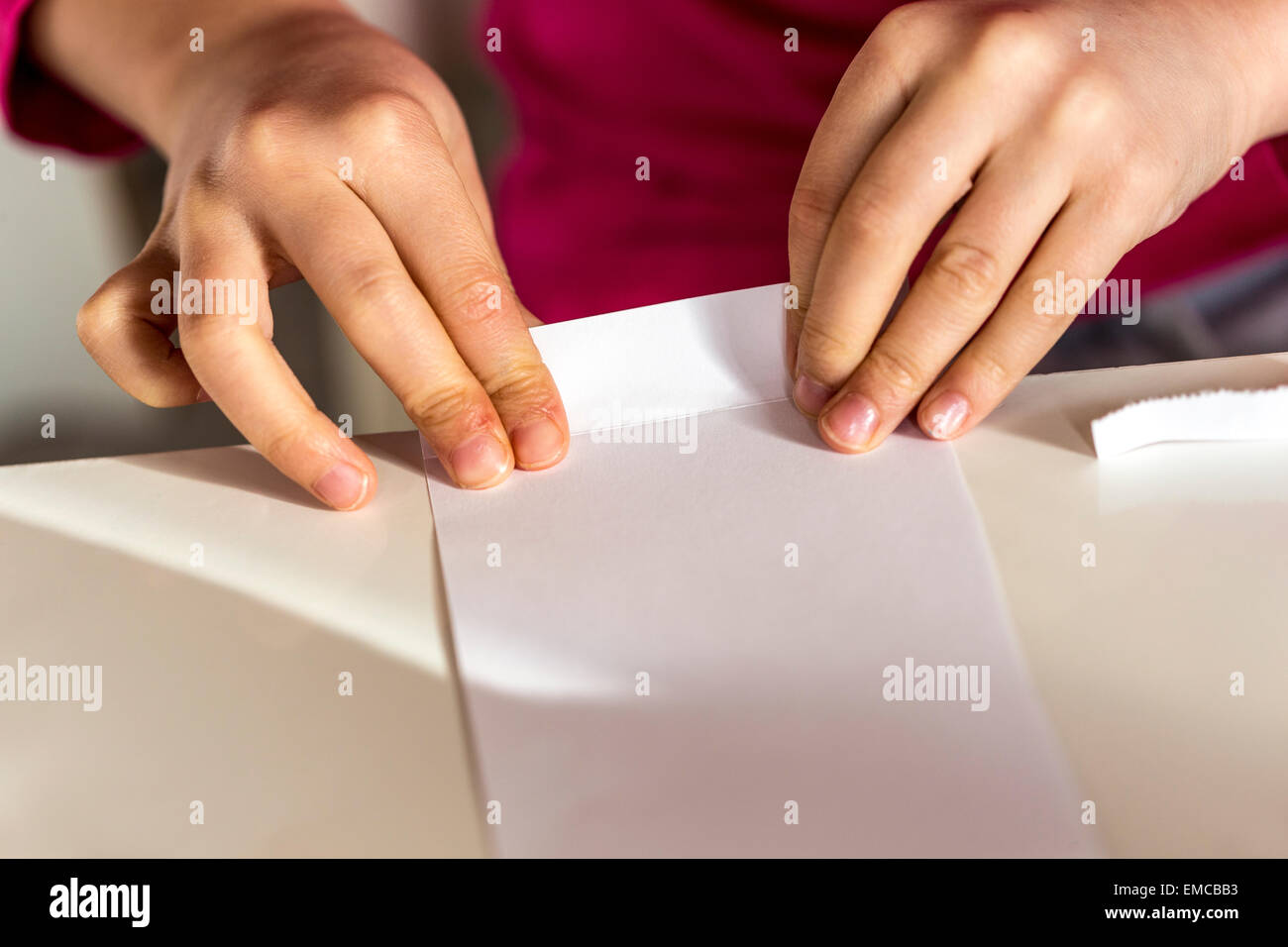 Girl folding piece of paper Stock Photo - Alamy