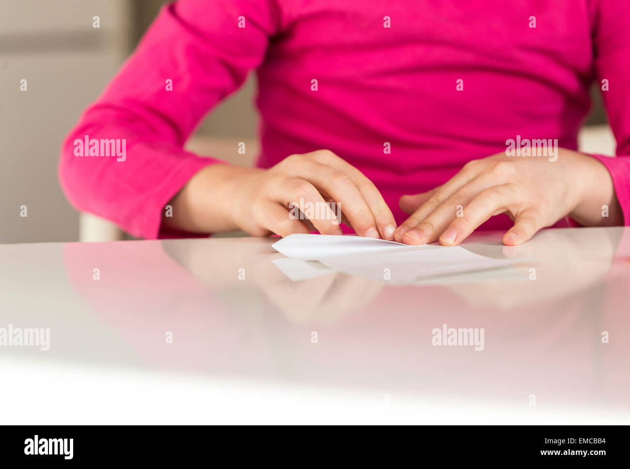 Girl folding piece of paper Stock Photo - Alamy
