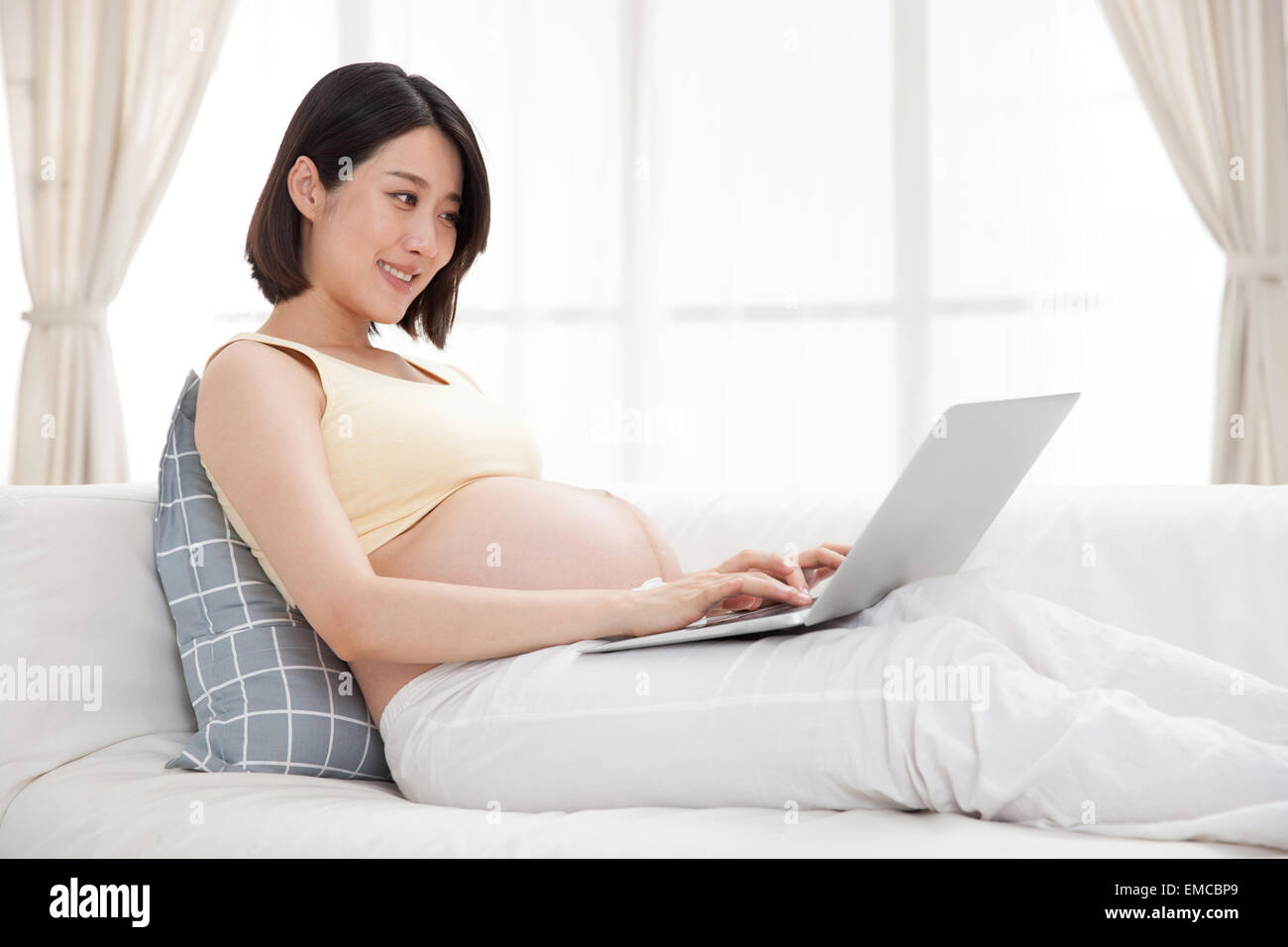 Pregnant women using notebook computer Stock Photo - Alamy