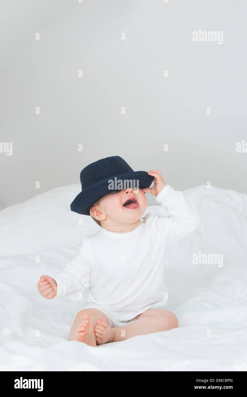 Baby girl with oversized hat Stock Photo - Alamy