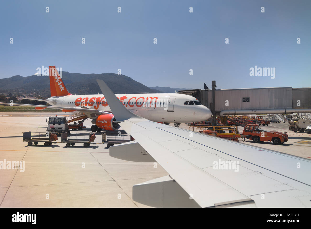 Easyjet airplane at the jet bridge on the runway at Malaga airport ...