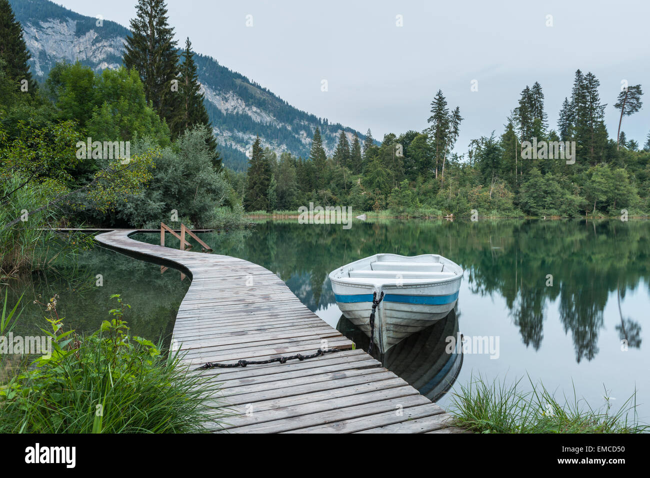 Switzerland, Grisons, Lake Cresta, wooden boardwalk and boat Stock ...