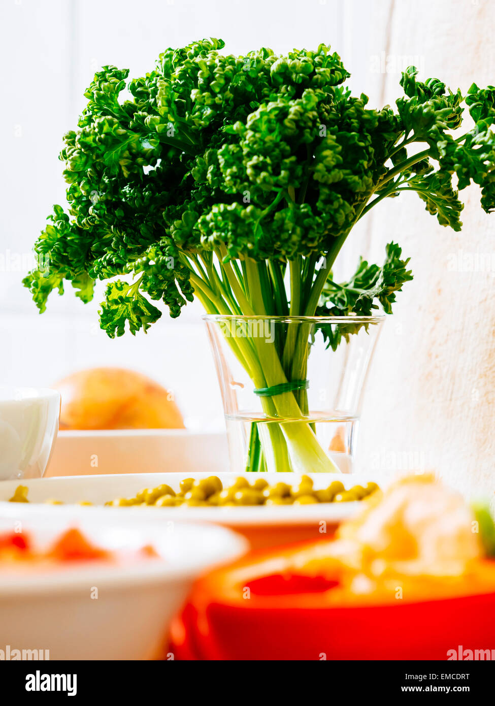 Fresh parsley in glass with vegetables in bowls Stock Photo - Alamy