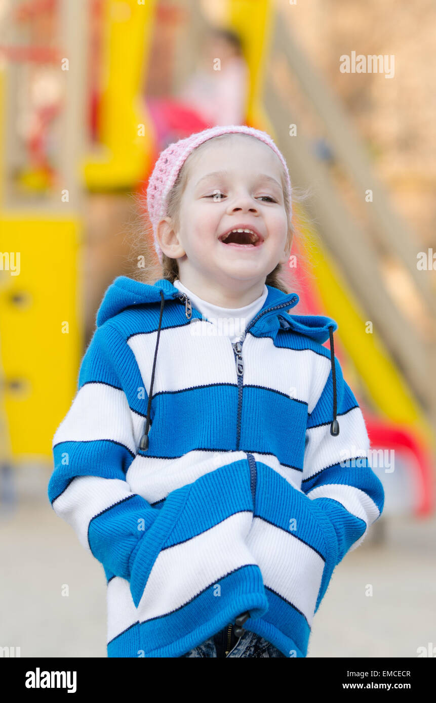 Four-year girl playing on the playground in the cool spring weather ...