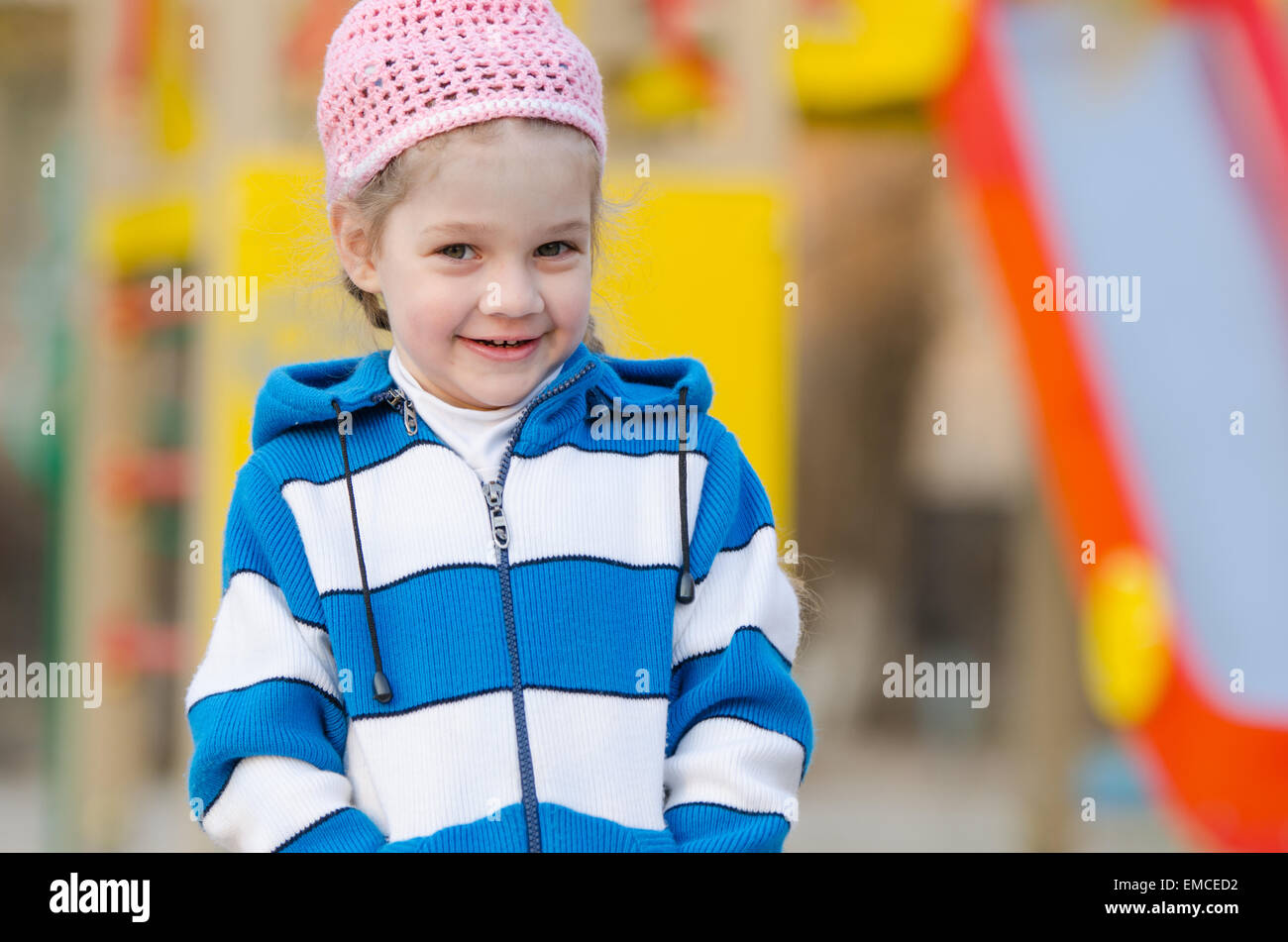 Four-year girl playing on the playground in the cool spring weather ...