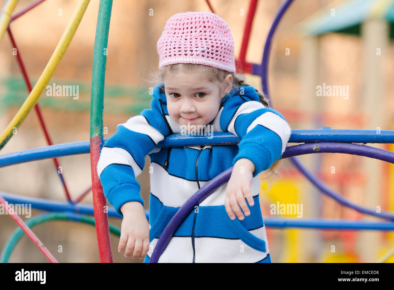 Four-year girl playing on the playground in the cool spring weather ...