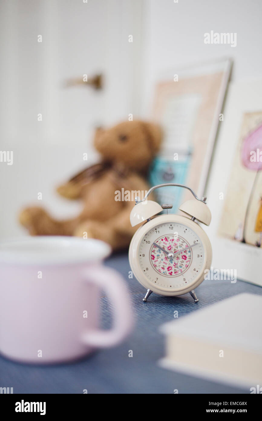 Floral pattern alarm clock on night table in girl's room Stock Photo ...