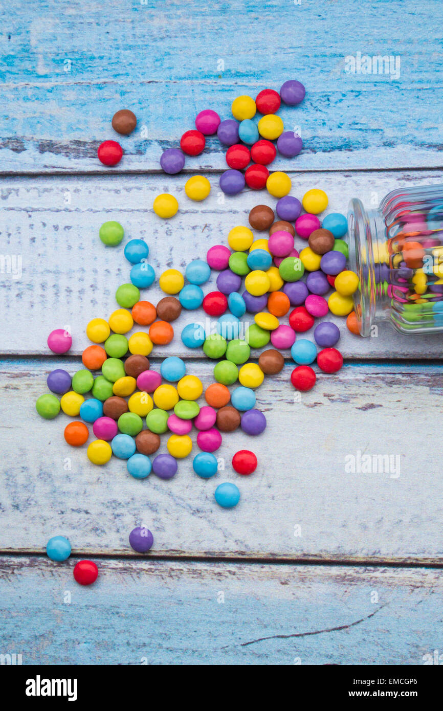 Smarties and candy jar on light blue wood Stock Photo - Alamy