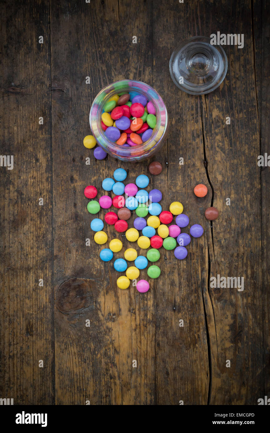 Smarties, candy jar and glass cover on wood Stock Photo - Alamy