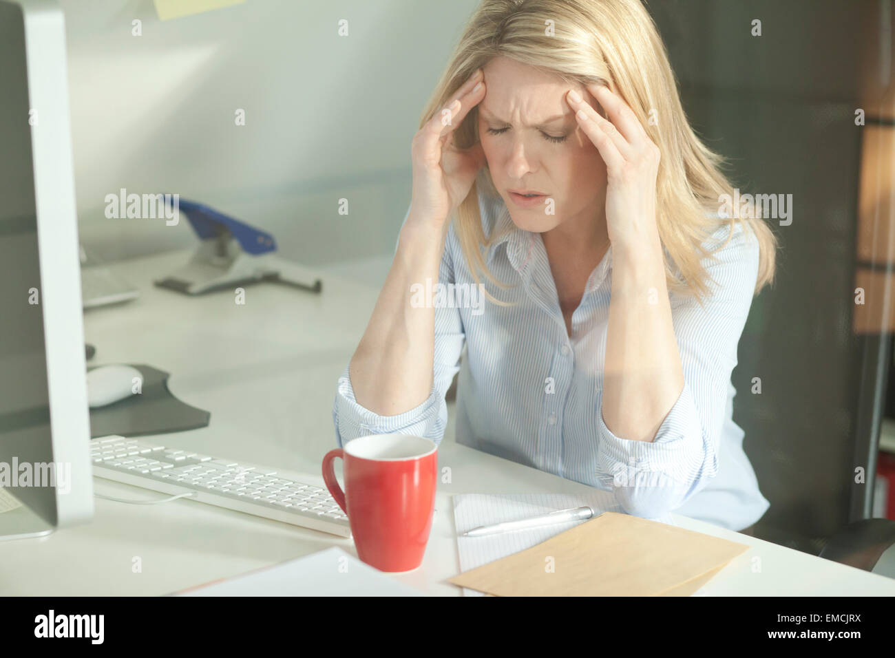 Exhausted woman sitting at desk at home Stock Photo - Alamy