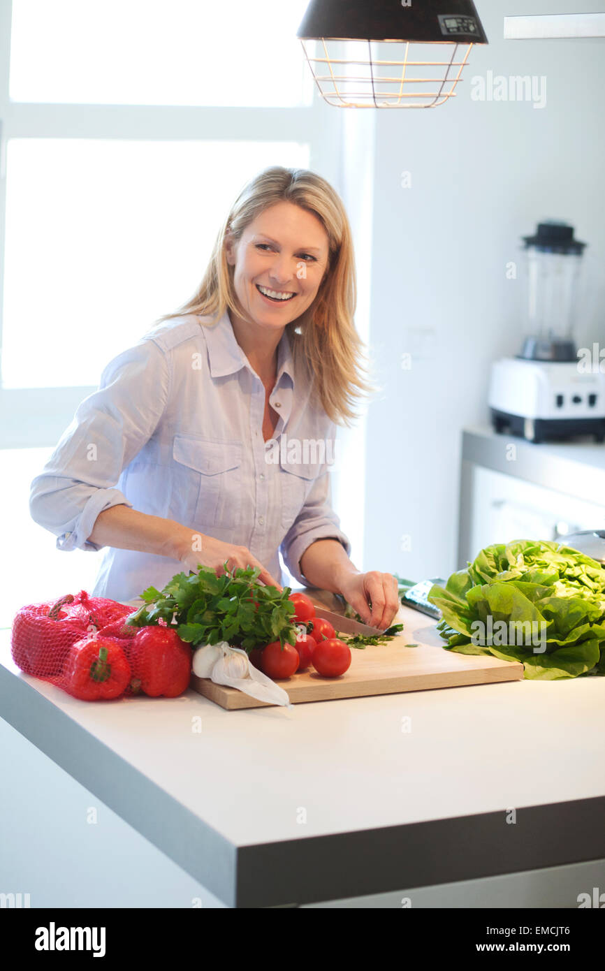 Smiling woman cooking in kitchen Stock Photo - Alamy