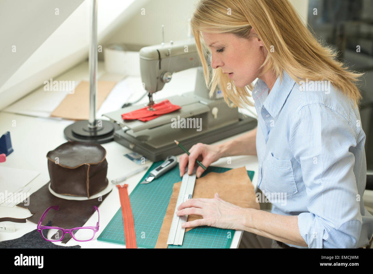 Woman at table tailoring Stock Photo - Alamy