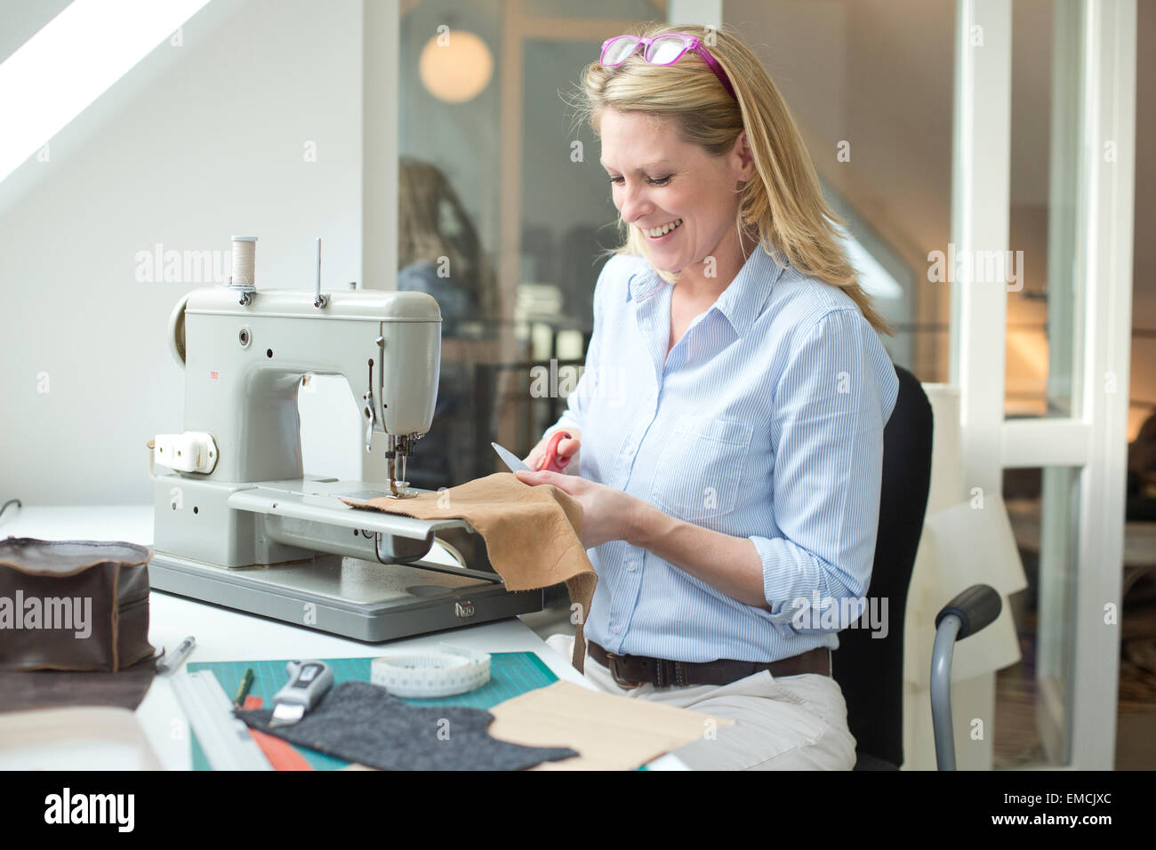 Smiling woman tailoring Stock Photo - Alamy