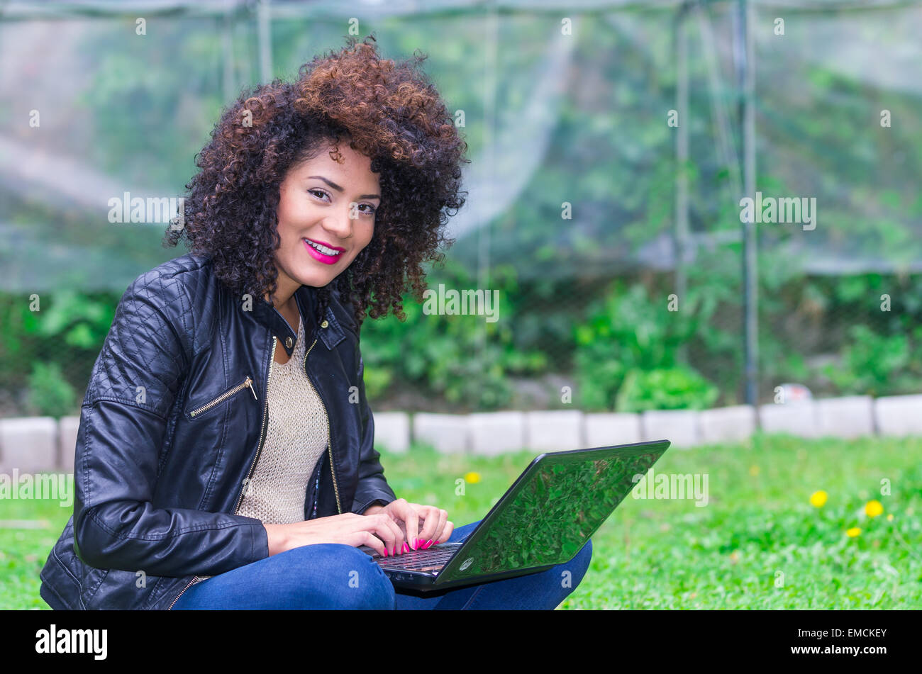 exotic beautiful young girl using laptop in the garden Stock Photo - Alamy