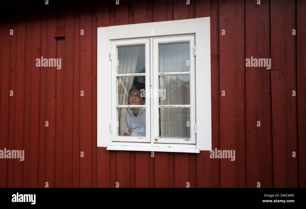 Norway, Lofoten, woman looking through window Stock Photo - Alamy