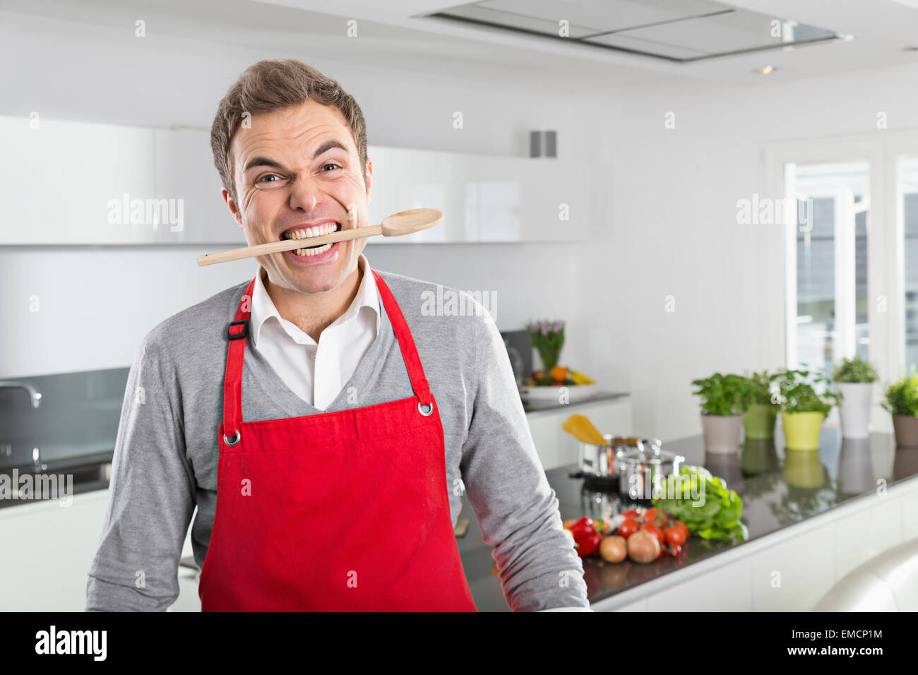 Portrait of man with cooking spoon between his teeth Stock Photo - Alamy