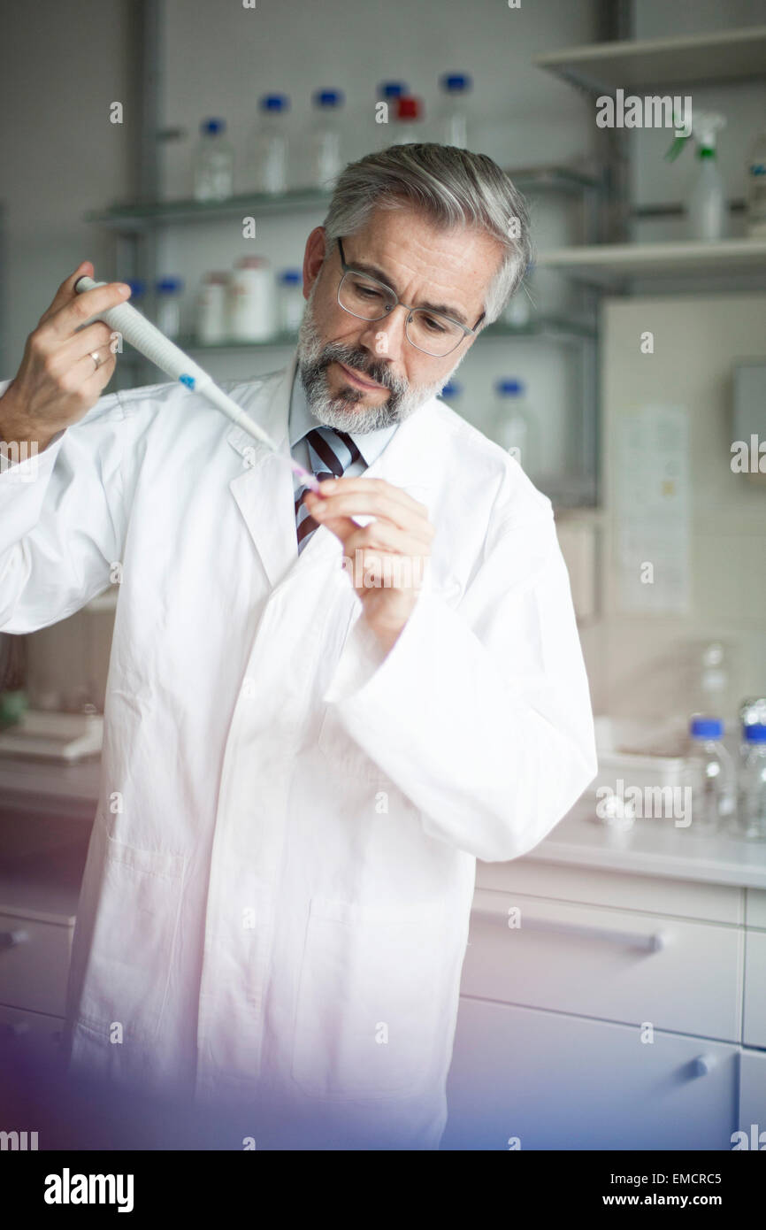 Scientist pouring liquid in test tube Stock Photo - Alamy