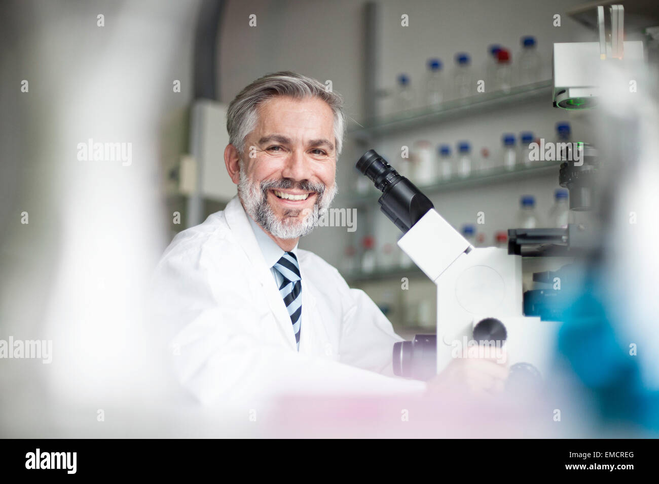 Portrait of smiling scientist in laboratory with microscope Stock Photo ...