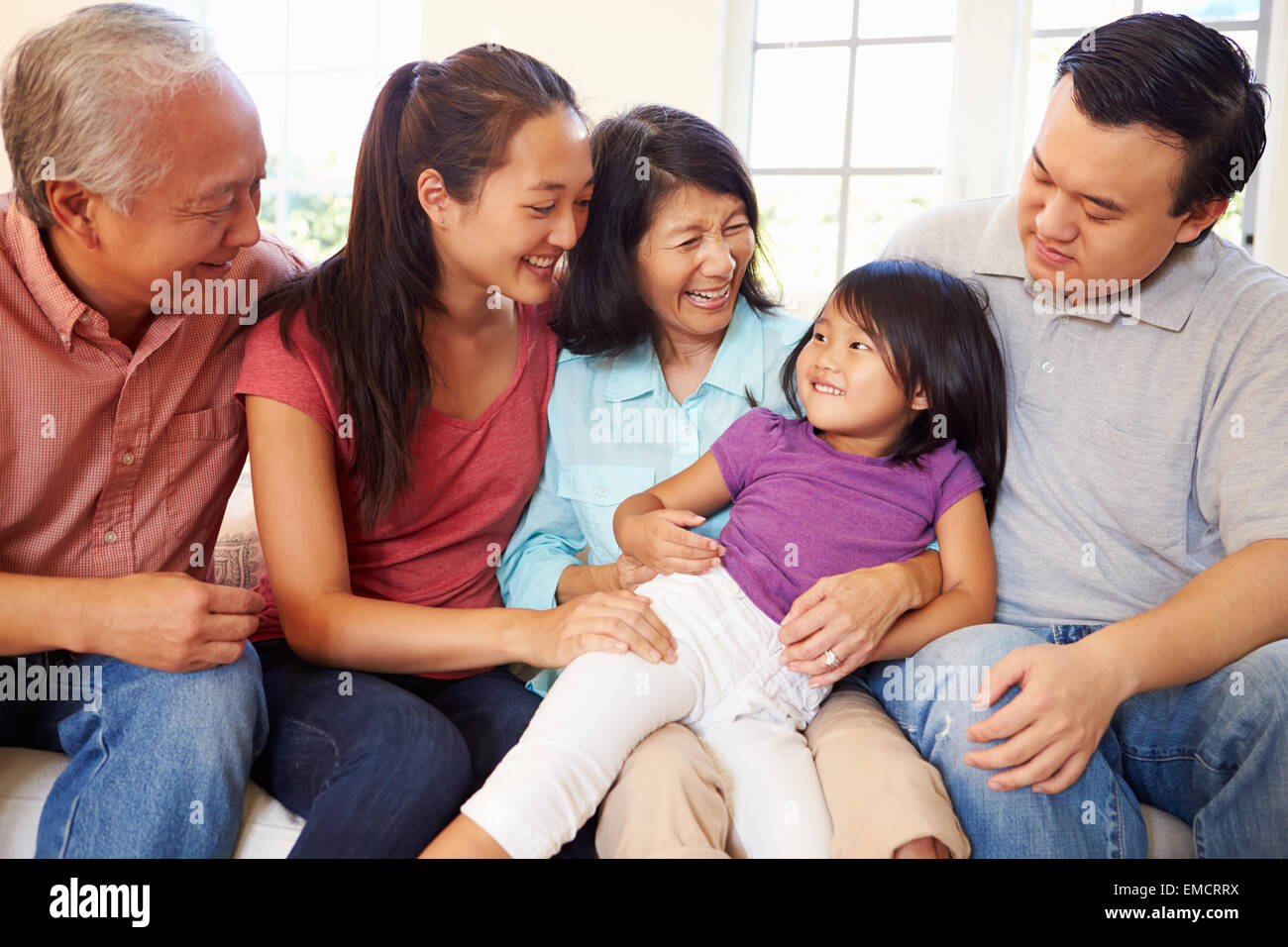 Multi Generation Family Sitting On Sofa At Home Together Stock Photo ...