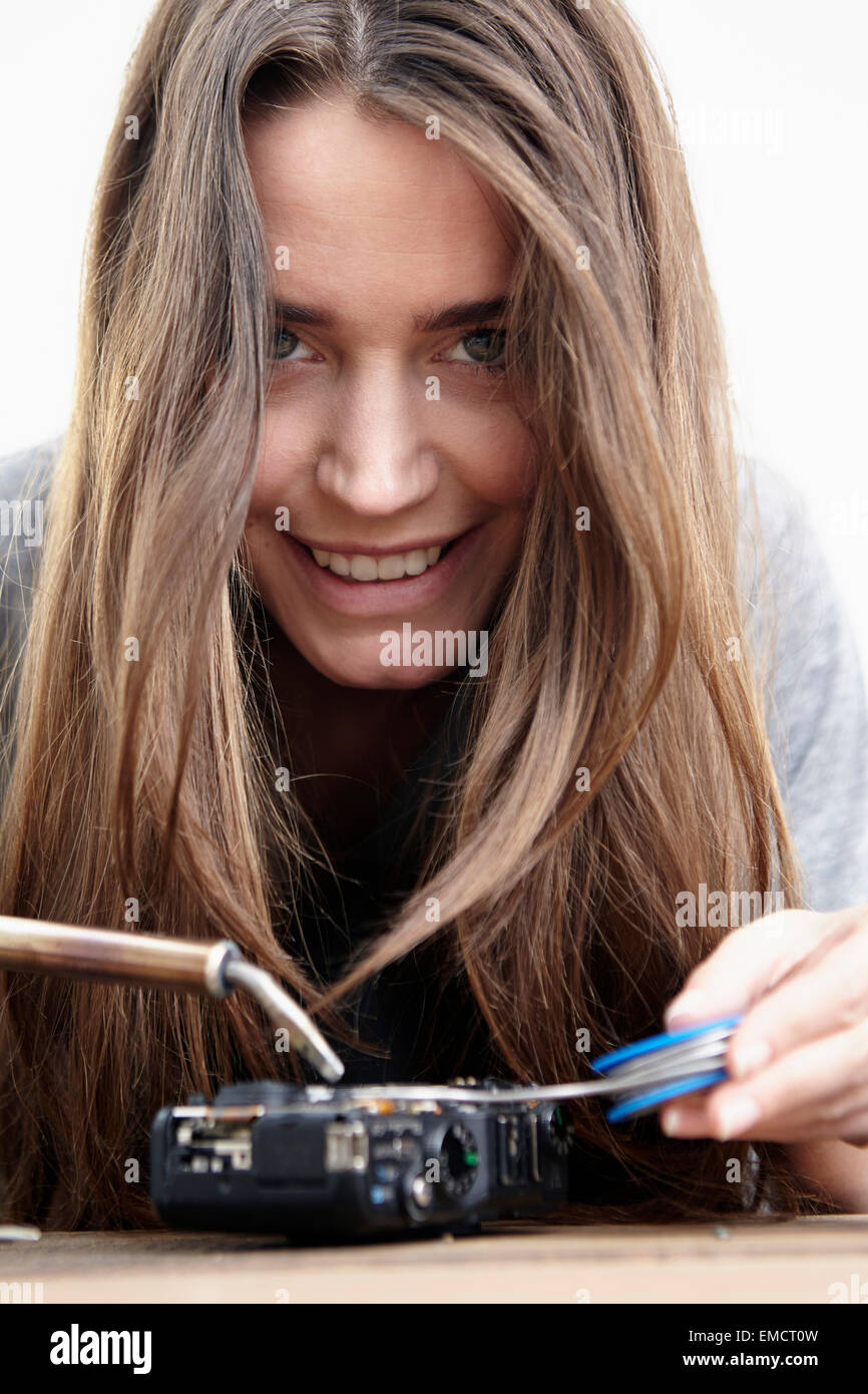 Young woman repairing camera Stock Photo - Alamy