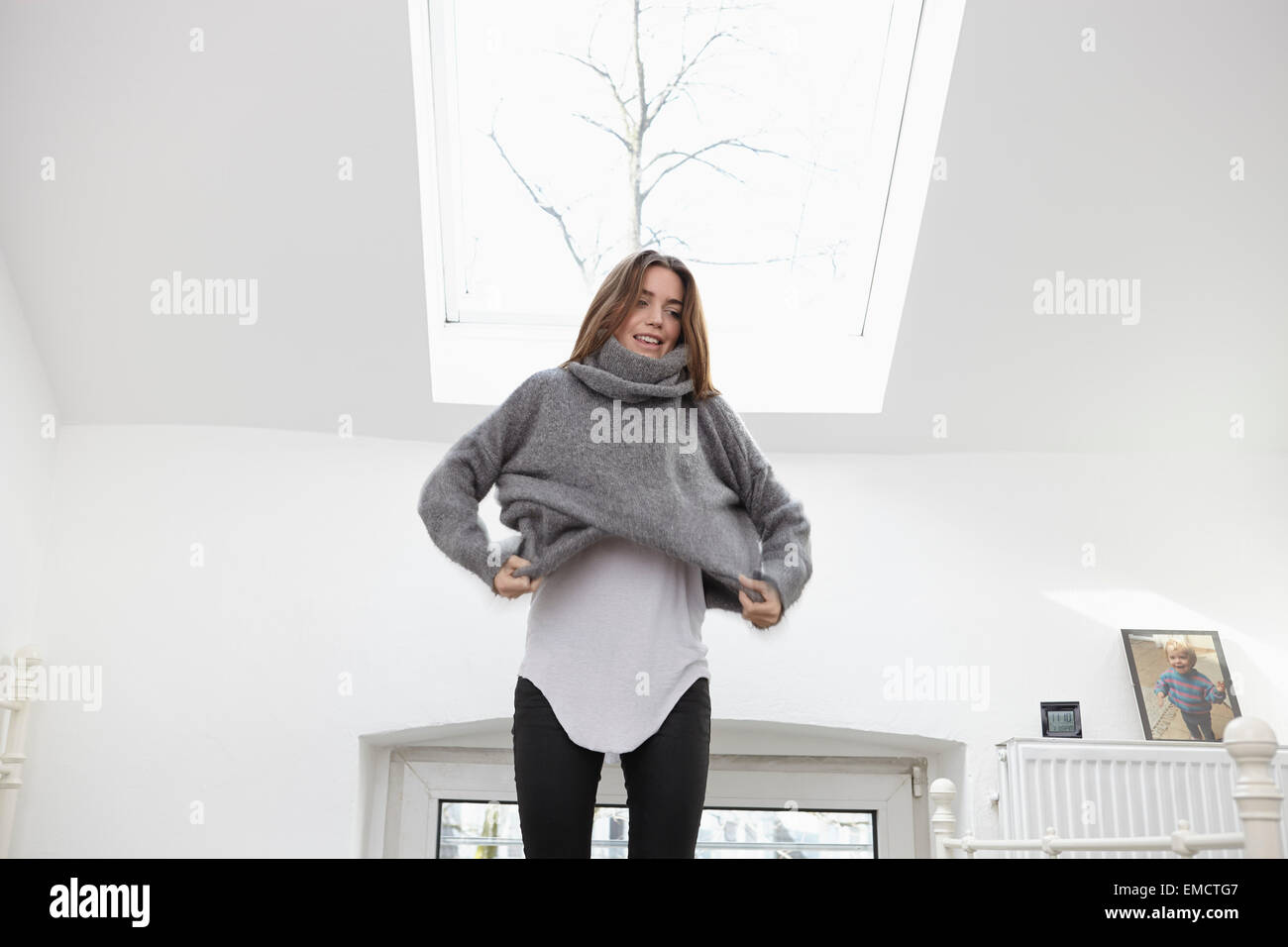Woman in bed room putting on pullover Stock Photo - Alamy