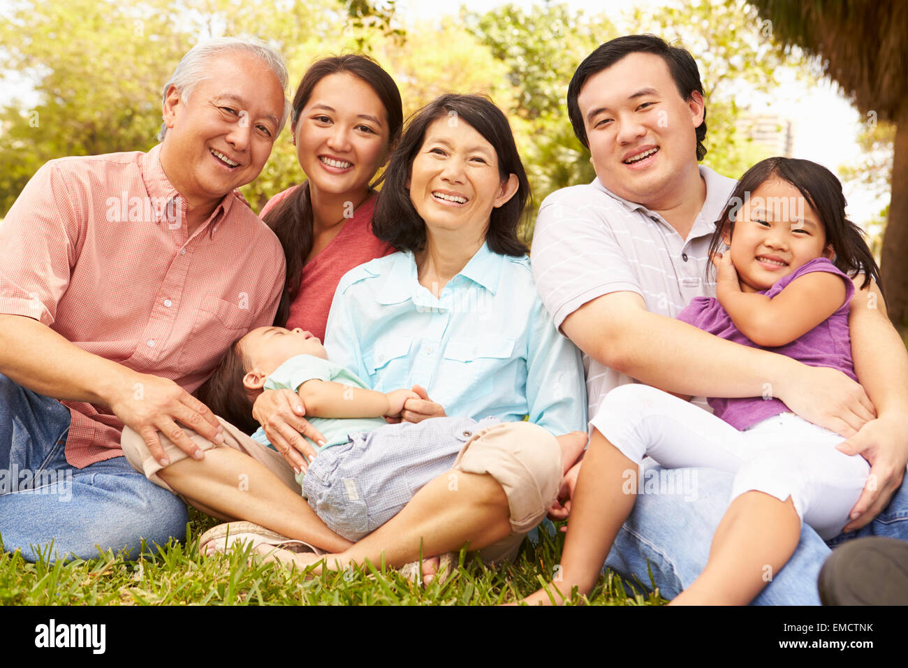 Multi Generation Family Sitting In Park Together Stock Photo - Alamy