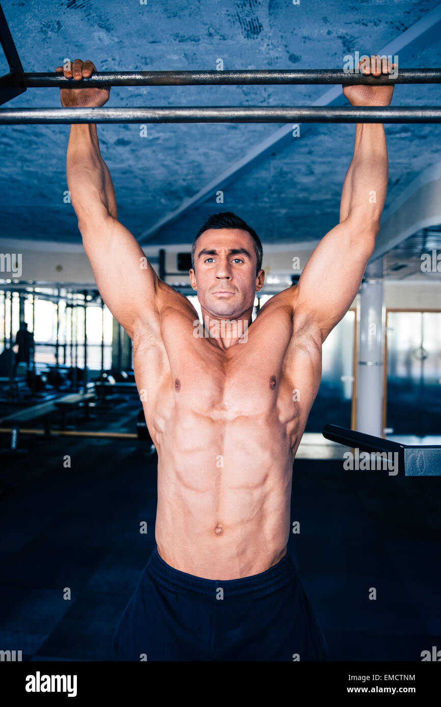 Muscular handsome man pulling up at gym Stock Photo - Alamy