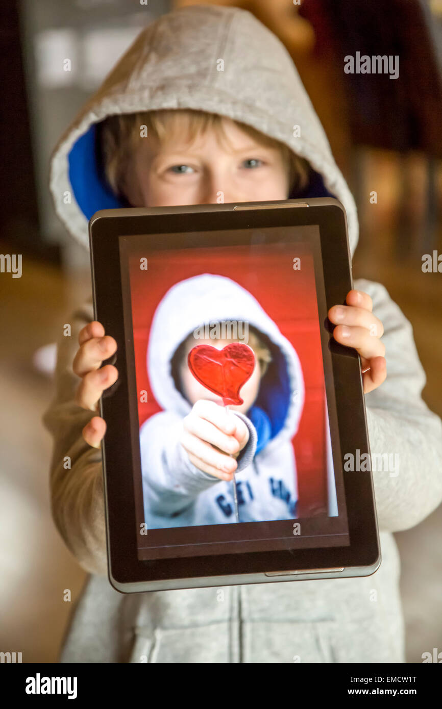Boy showing digital tablet with photography of himself Stock Photo - Alamy