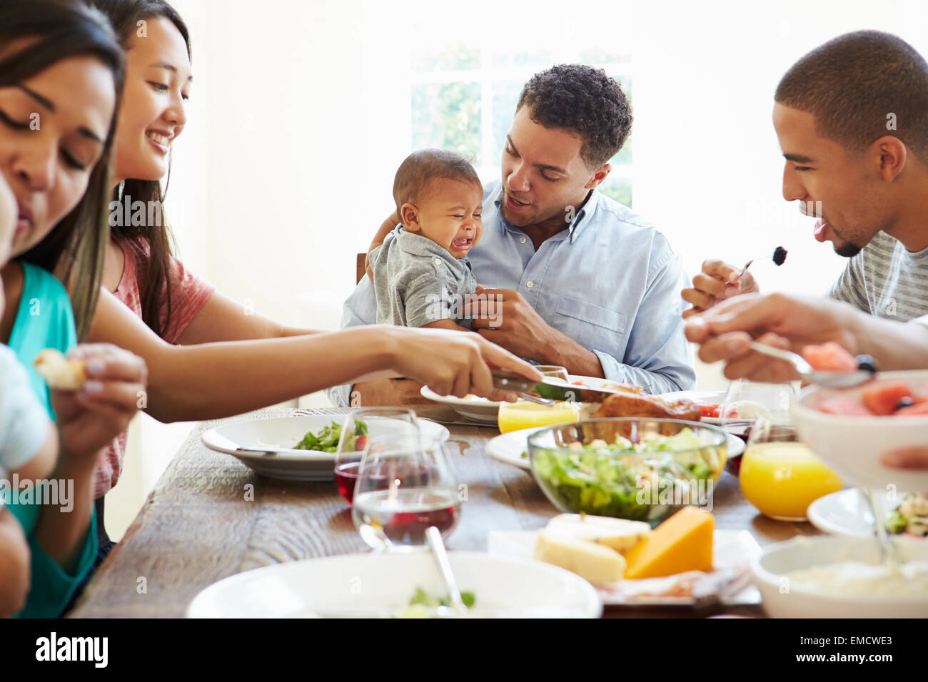Group Of Friends With Babies Enjoying Meal At Home Together Stock Photo ...