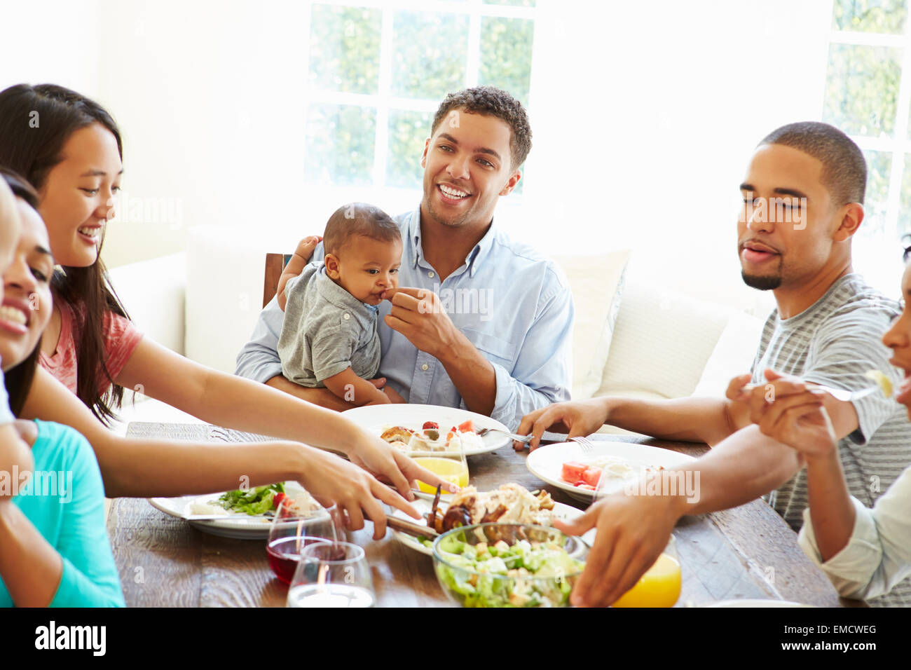 Group Of Friends With Babies Enjoying Meal At Home Together Stock Photo ...