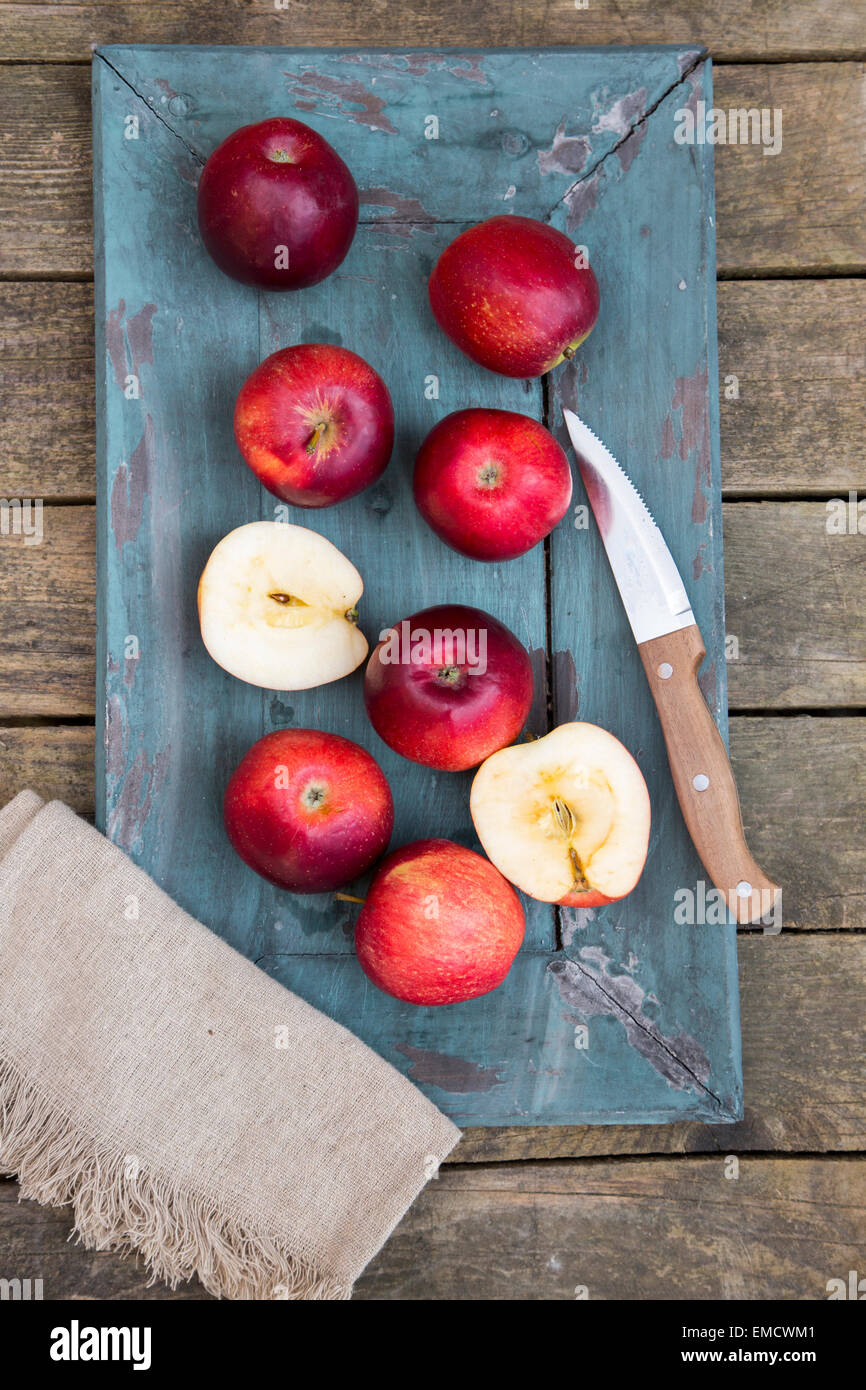 Red apples, knife and place mat on dark wood Stock Photo - Alamy