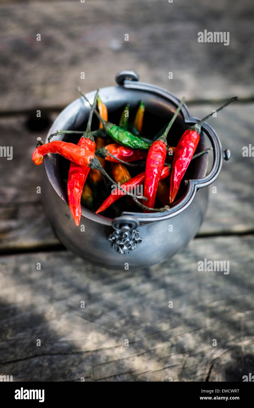 Tin vessel of red and green chili pods Stock Photo - Alamy