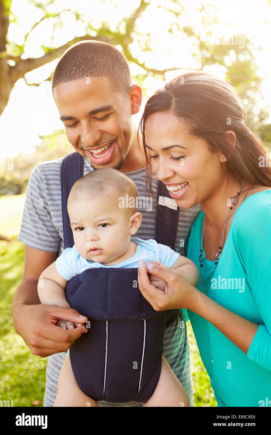 Family With Baby Son In Carrier Walking Through Park Stock Photo - Alamy