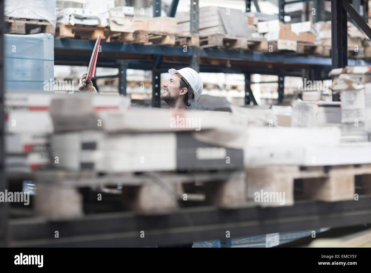 Warehouseman in storehouse holding clipboard Stock Photo - Alamy