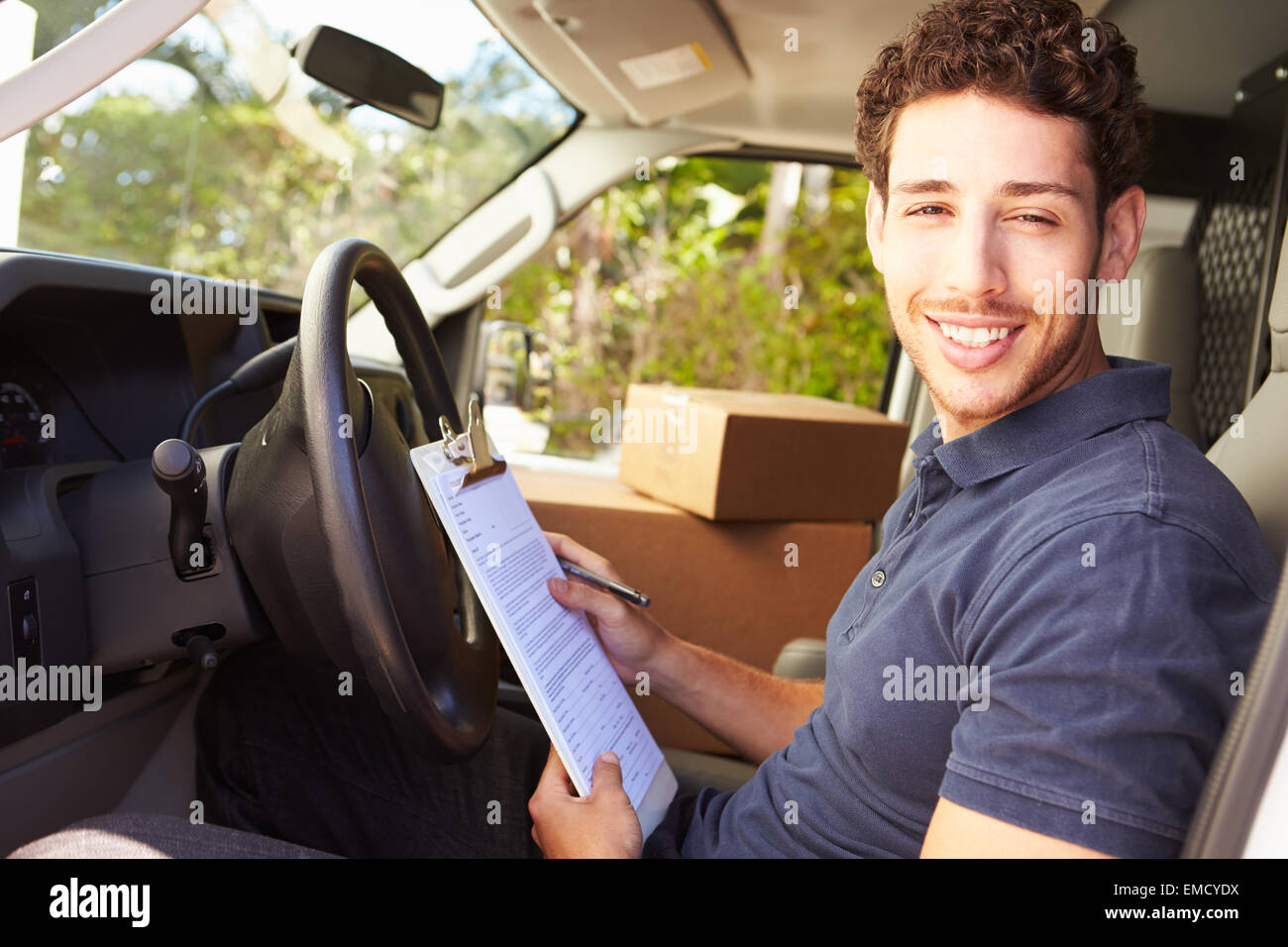 Delivery Driver Sitting In Van Filling Out Paperwork Stock Photo - Alamy