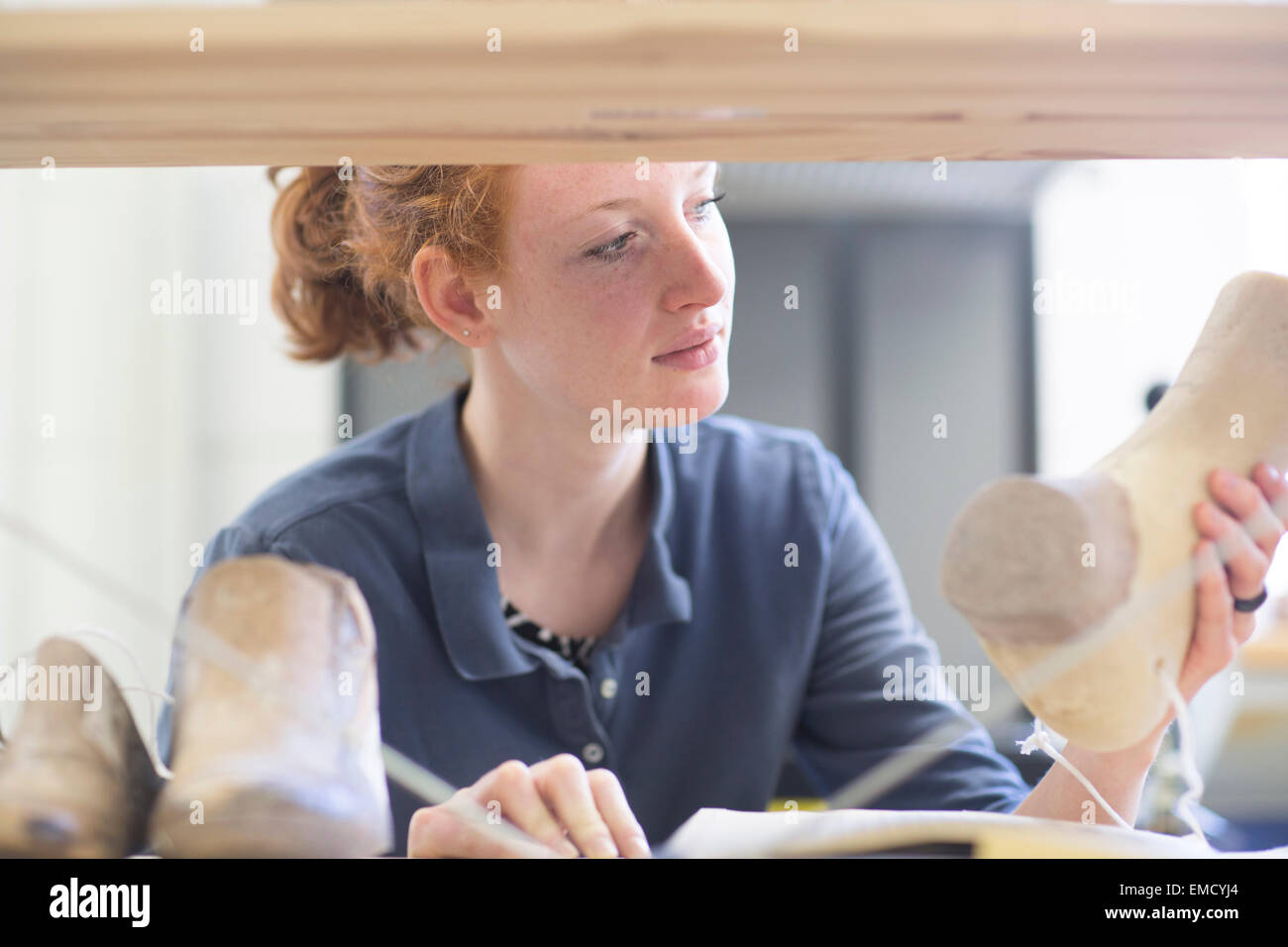 Female shoemaker looking at last Stock Photo - Alamy