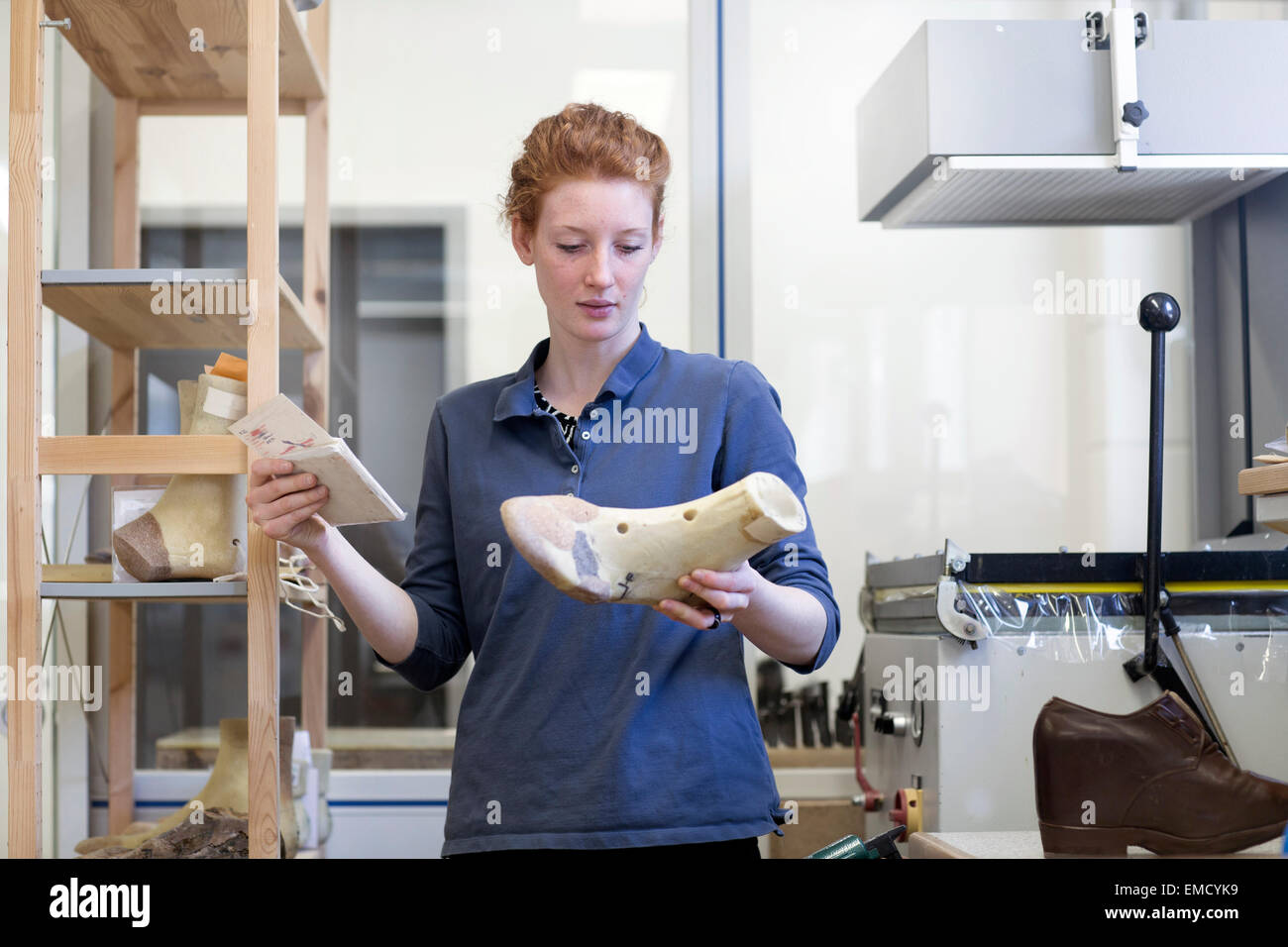 Female shoemaker looking at last Stock Photo - Alamy
