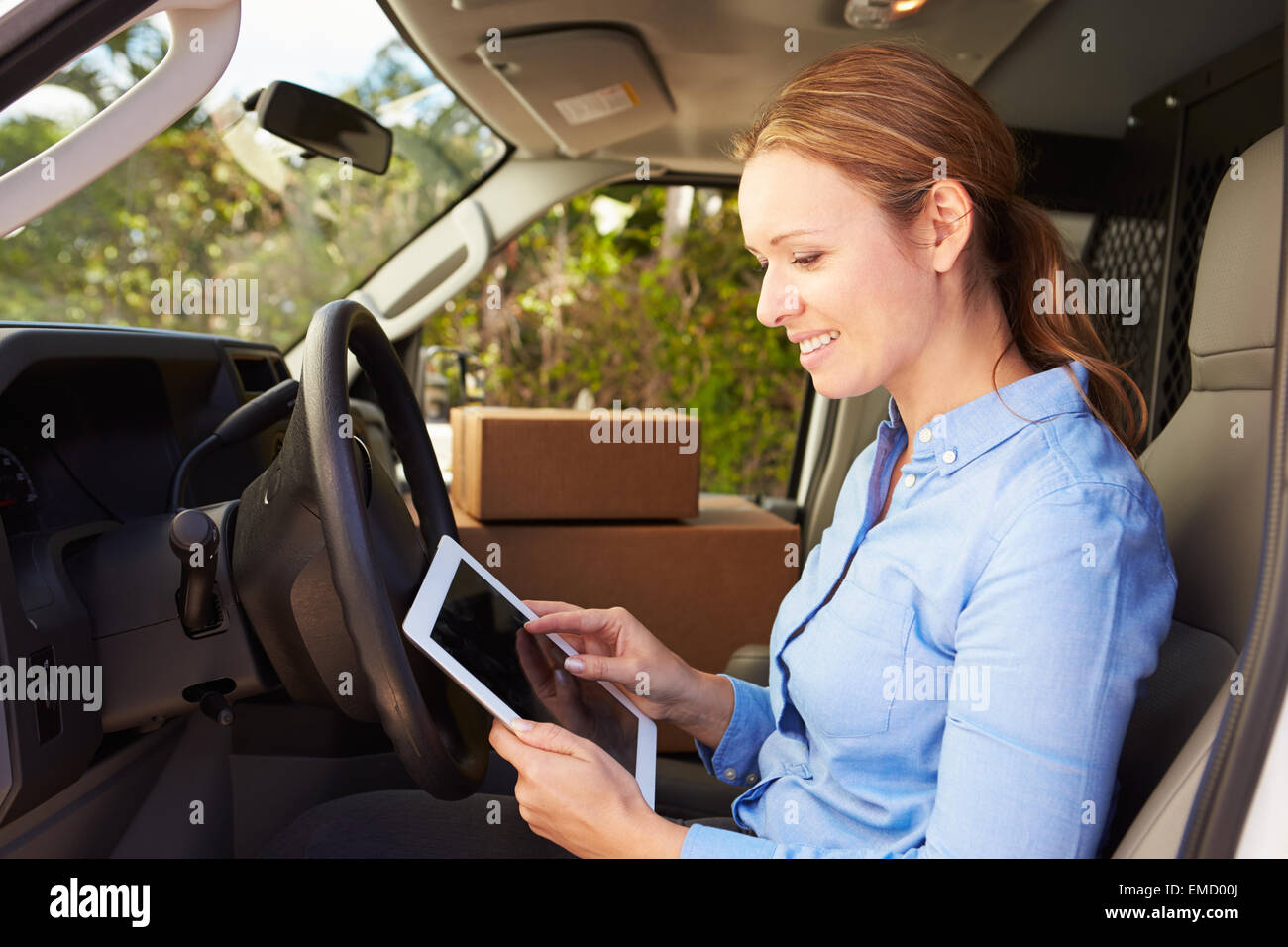 Female Delivery Driver Sitting In Van Using Digital Tablet Stock Photo ...