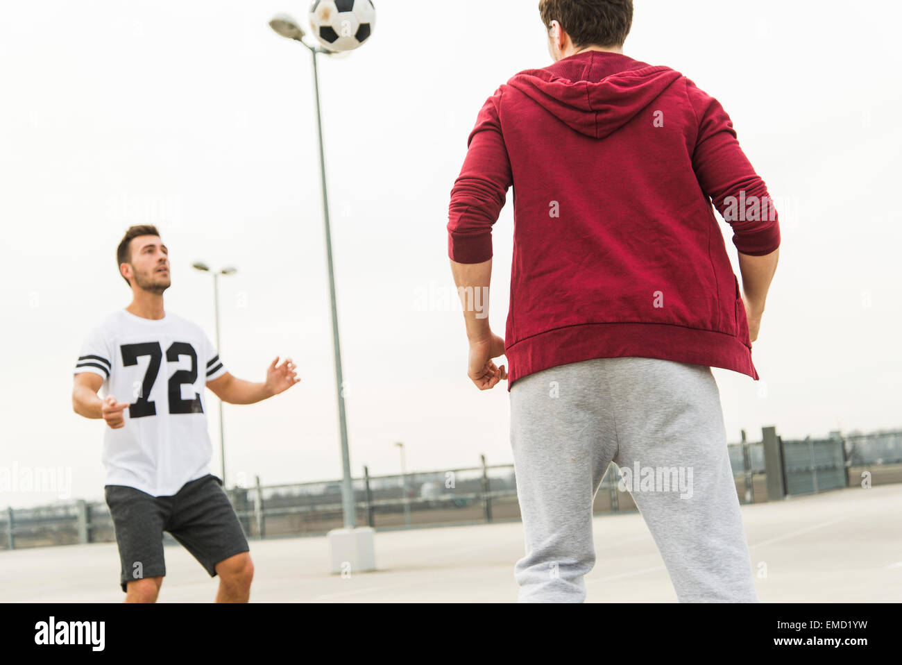 Two young men playing soccer on parking level Stock Photo - Alamy