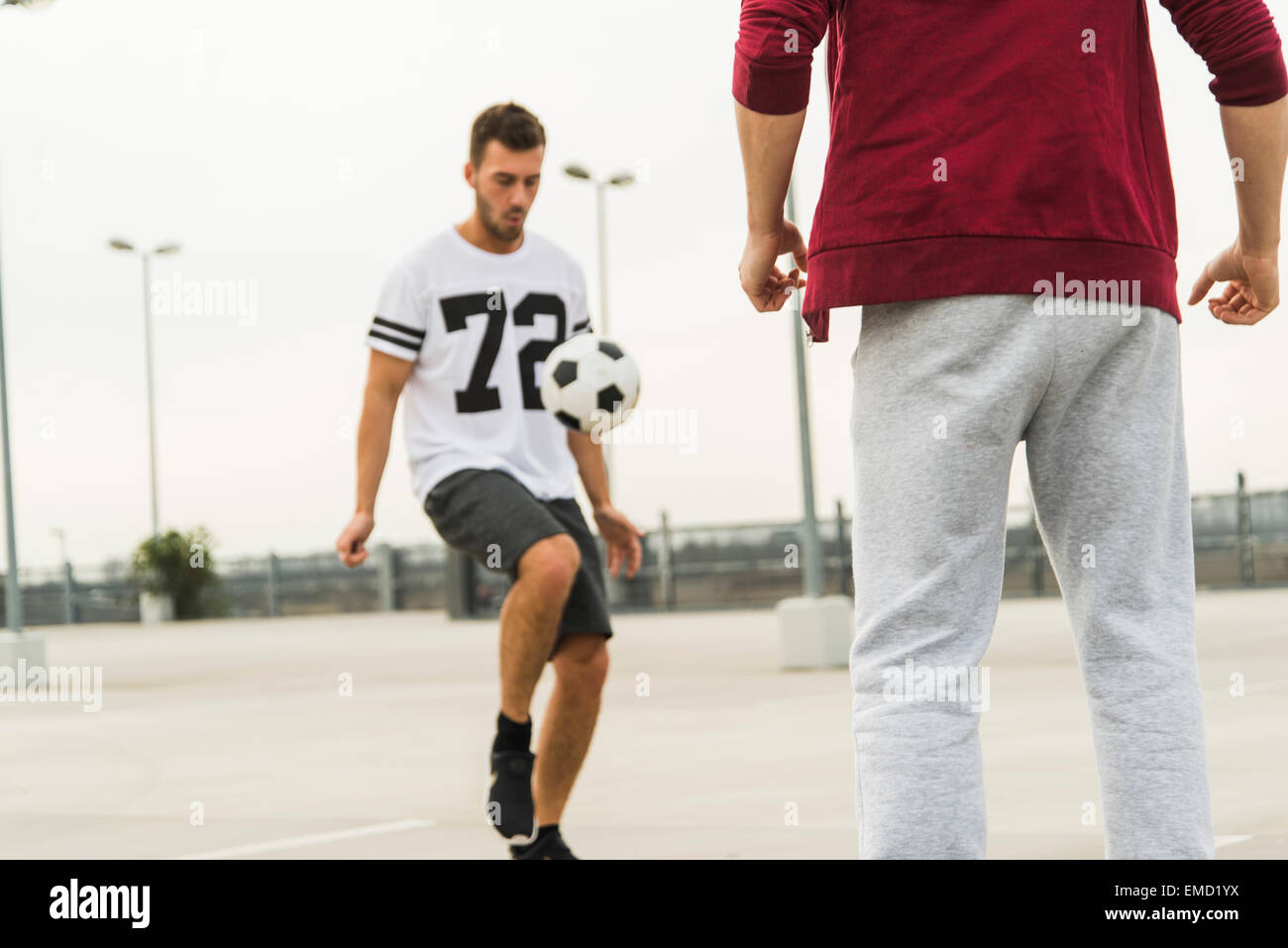 Two young men playing soccer on parking level Stock Photo - Alamy