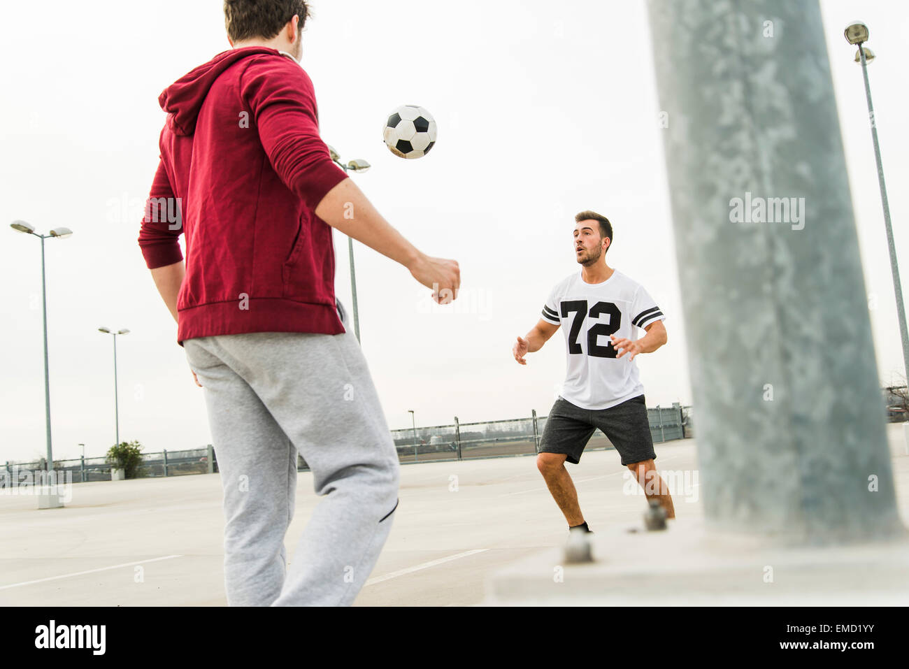 Two young men playing soccer on parking level Stock Photo - Alamy