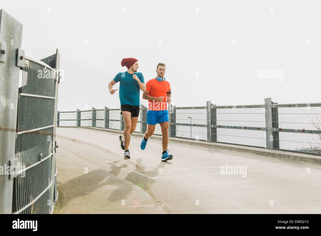 Two young men jogging on bridge Stock Photo - Alamy