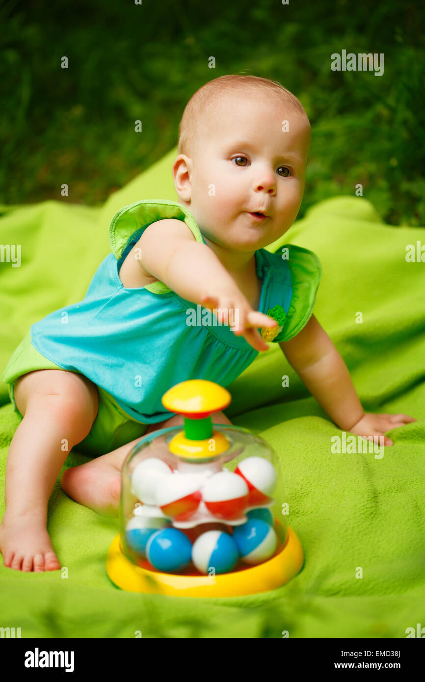 Adorable Toddler Baby Girl playing with toys on green Plaid in the ...