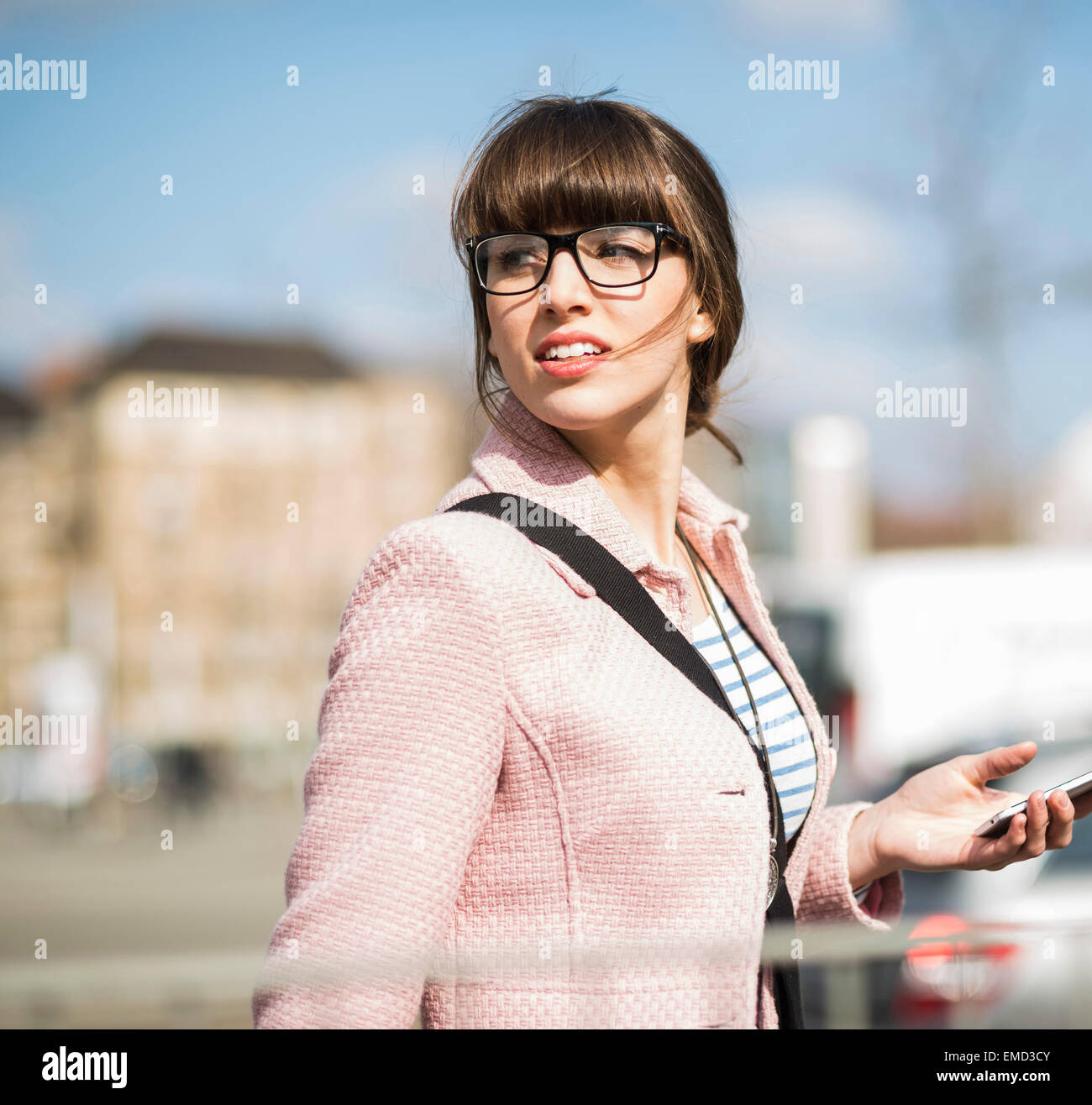 Young woman walking in street, using mobile phone Stock Photo - Alamy