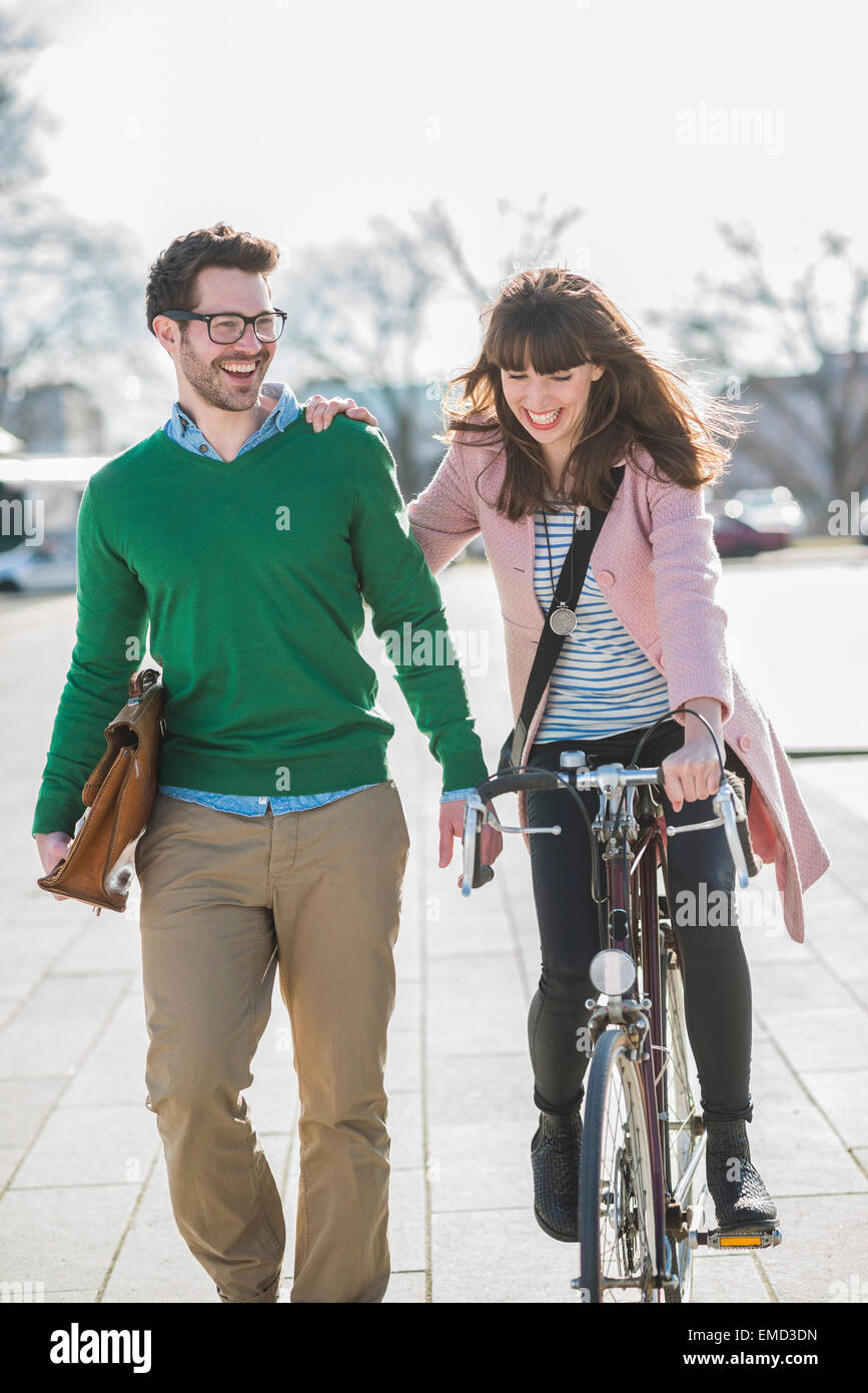 Happy couple going home together, woman riding bicycle Stock Photo - Alamy