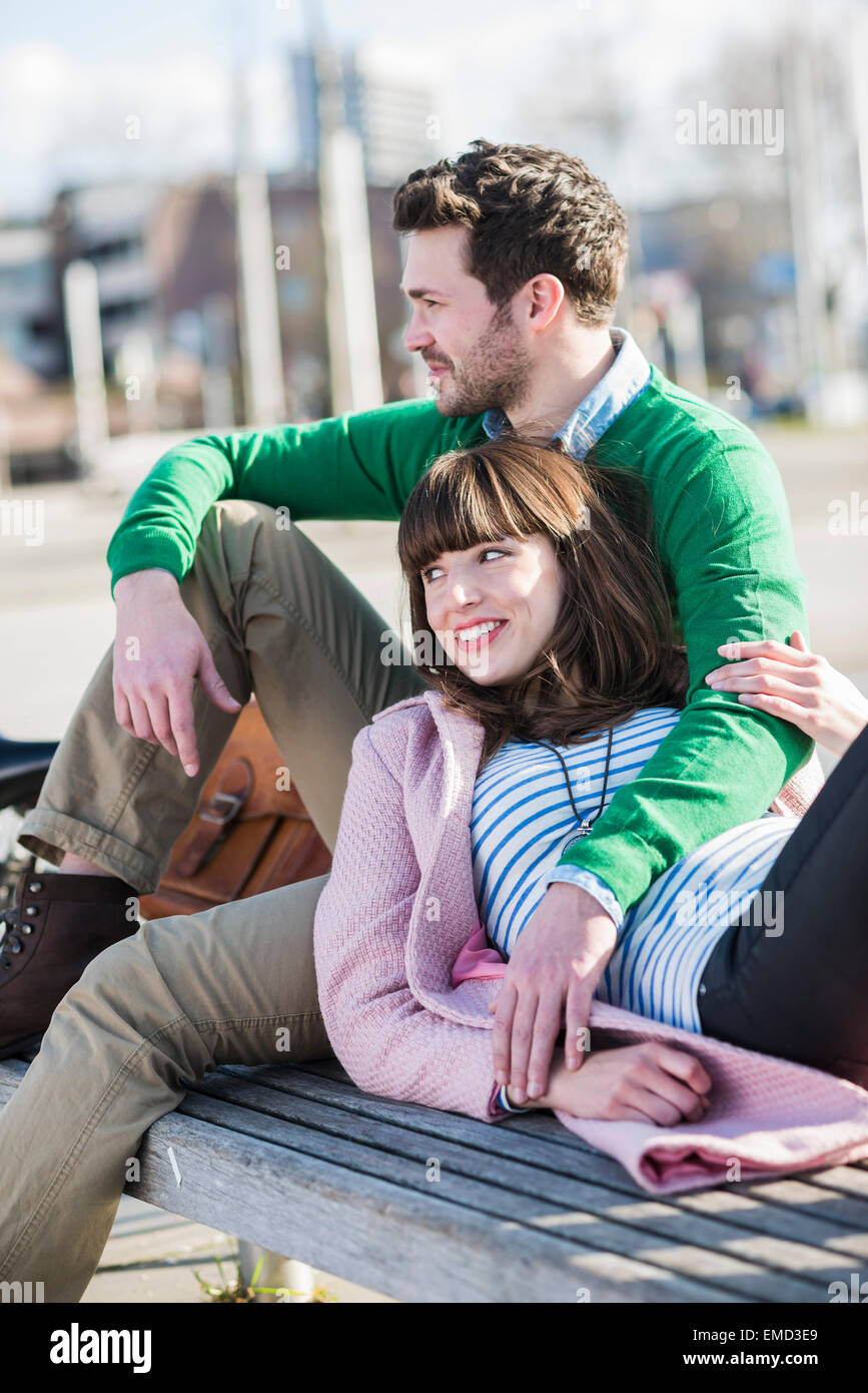 Happy couple resting on bench Stock Photo - Alamy