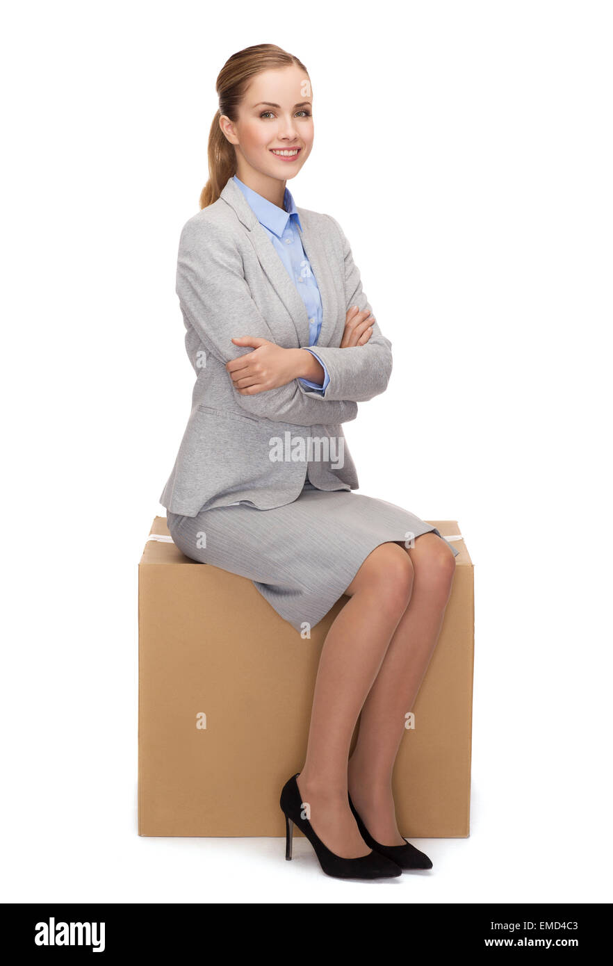 smiling woman sitting on cardboard box Stock Photo - Alamy